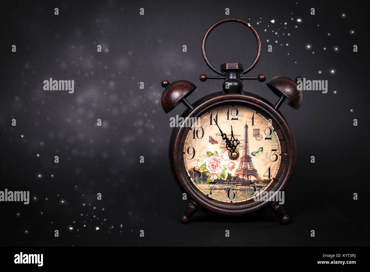 Photo of an old vintage clock on black background with sparkles and ...