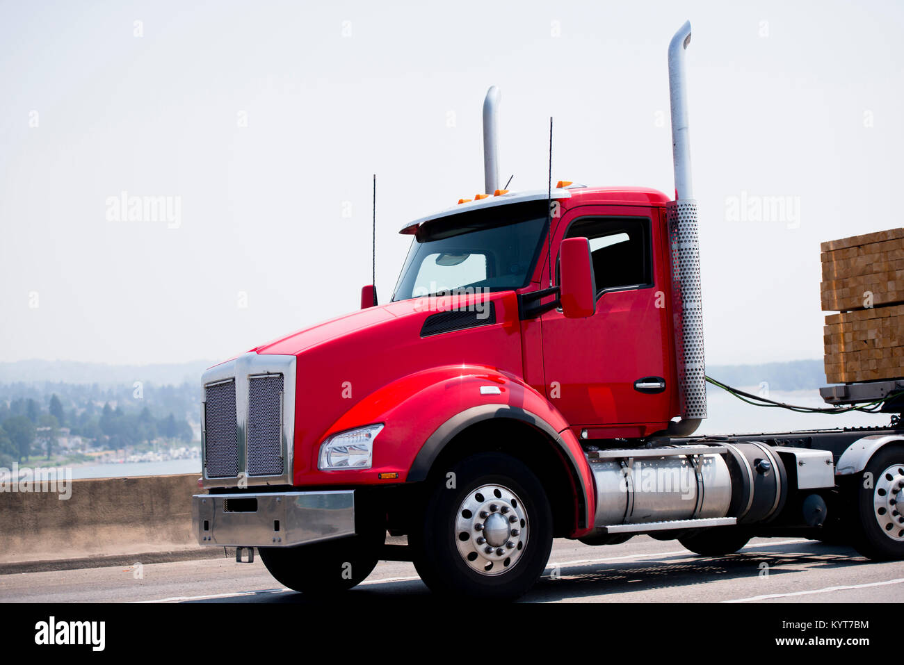 A modern simple powerful bright red big rig semi truck with day cab ...