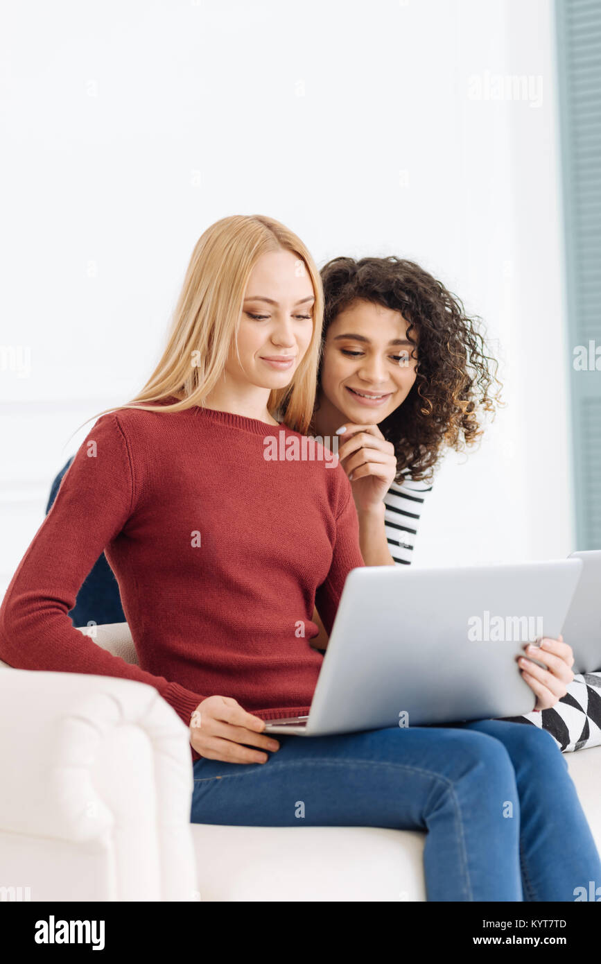 Two females watching interesting video Stock Photo - Alamy