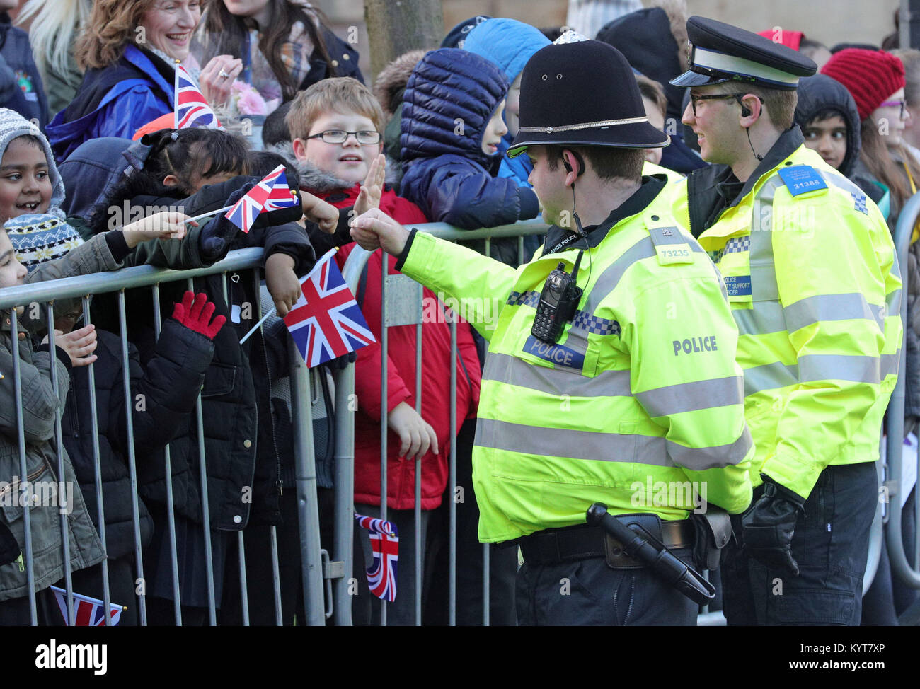 Police officers high five children as they await the arrival of the ...