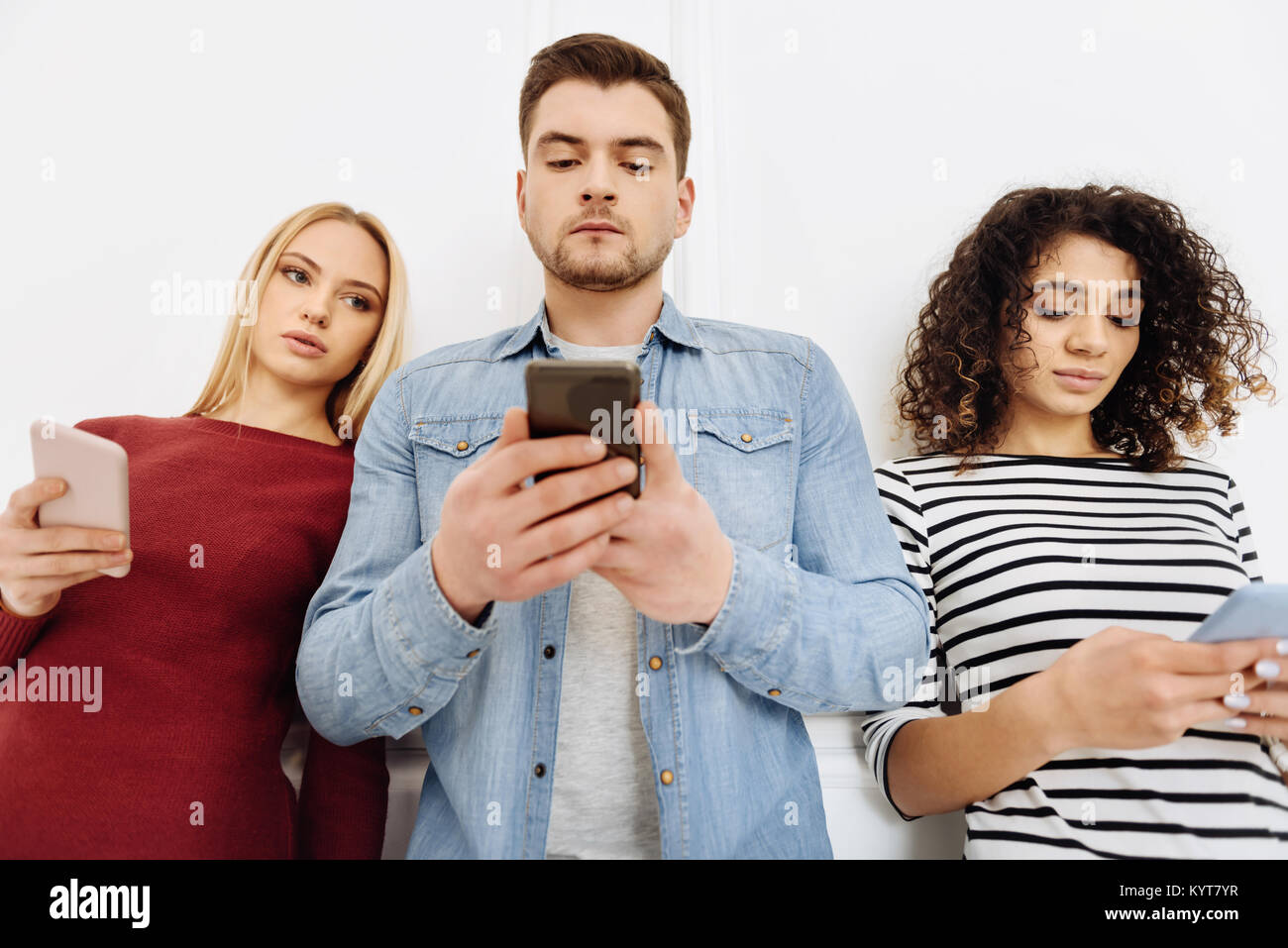 Concentrated male person looking at his smartphone Stock Photo - Alamy