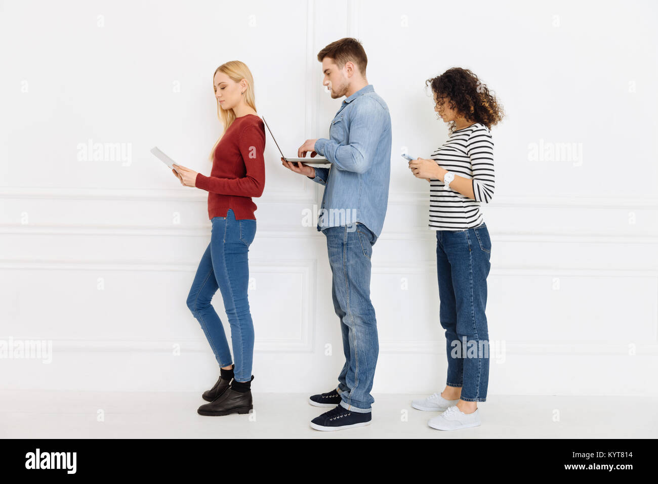 Busy young people standing in semi position Stock Photo - Alamy