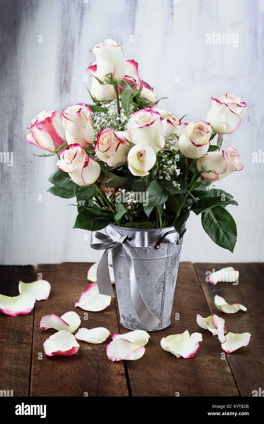 Beautiful bouquet of red and white roses with baby's breath in a metal ...