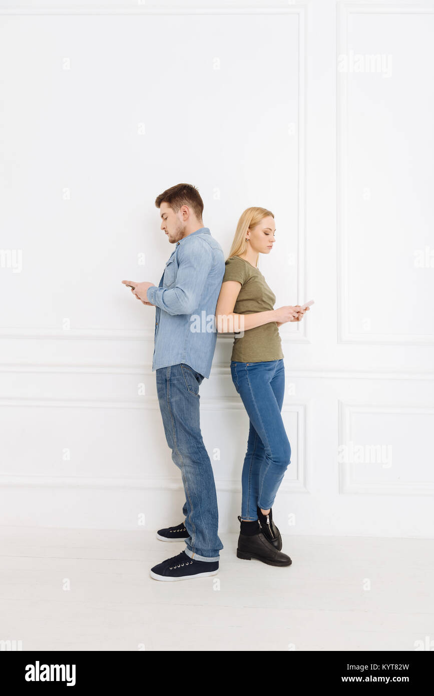 Upset couple standing against white background Stock Photo - Alamy