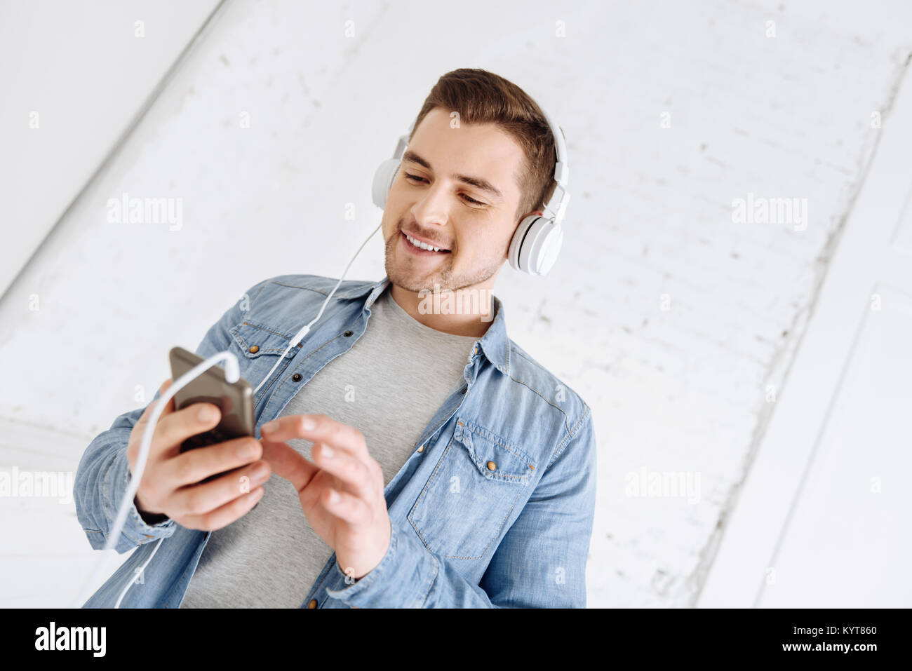 Cheerful male person using his gadget with pleasure Stock Photo - Alamy