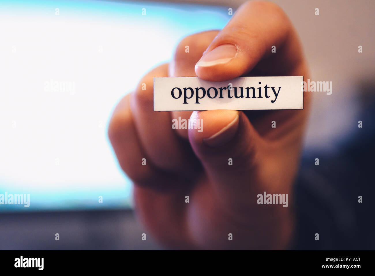 Close up of hand holding western script sign reading opportunity in ...