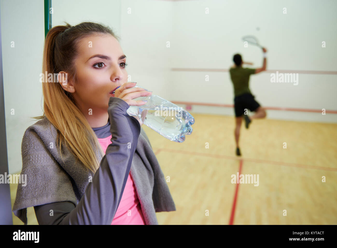 Woman drinking water after finished squash competition Stock Photo - Alamy