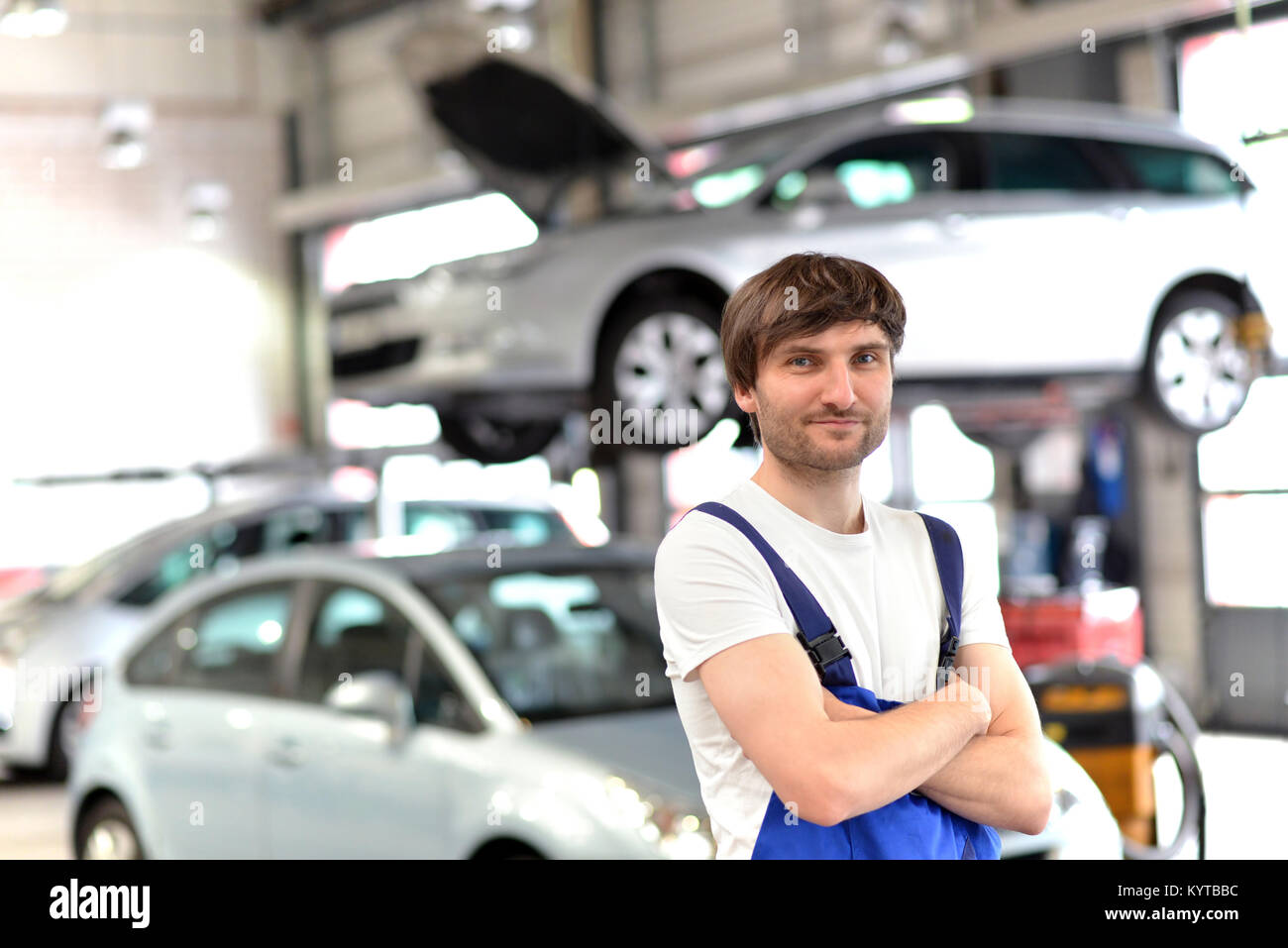 portrait smiling car mechanic in a workshop - closeup with in the ...