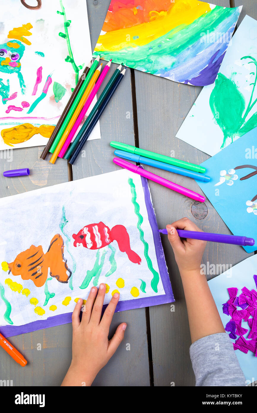 Child drawing. Top view of child hands with pencil painting picture on ...
