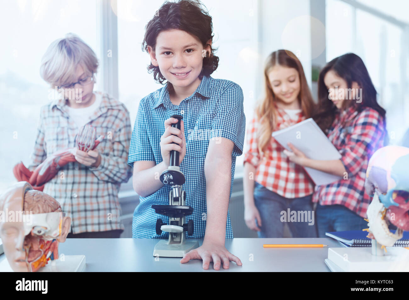 Learning new things. Committed clever young boy standing at the table ...
