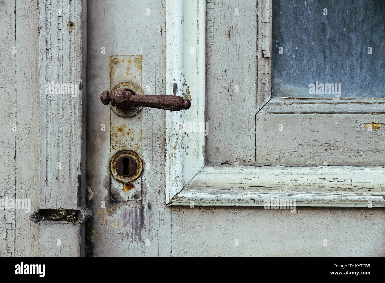 Old vintage and rusty door handle installed on an old grey weathered ...