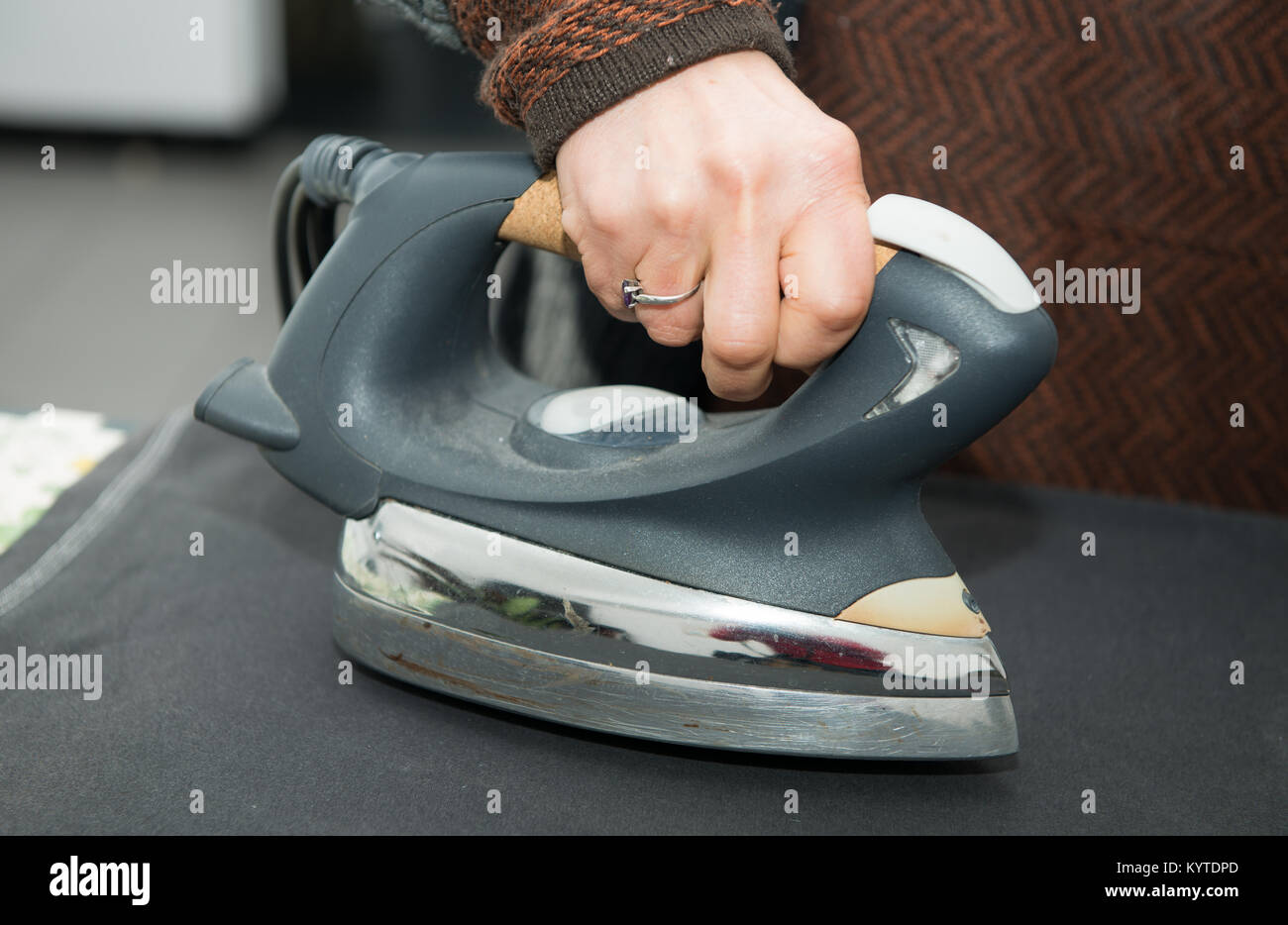 a woman ironing a black clothe, close-up Stock Photo - Alamy
