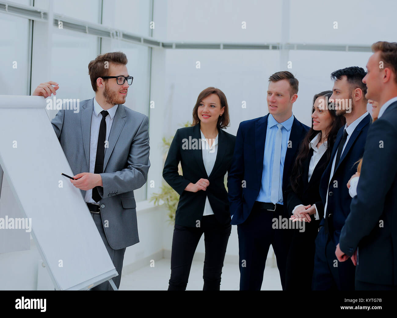 group of smiling friends staying together and looking at camera ...