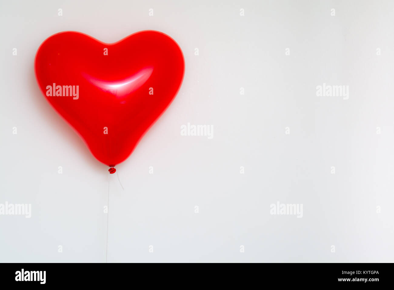 Red heart shaped balloon on a string isolated on white Stock Photo - Alamy