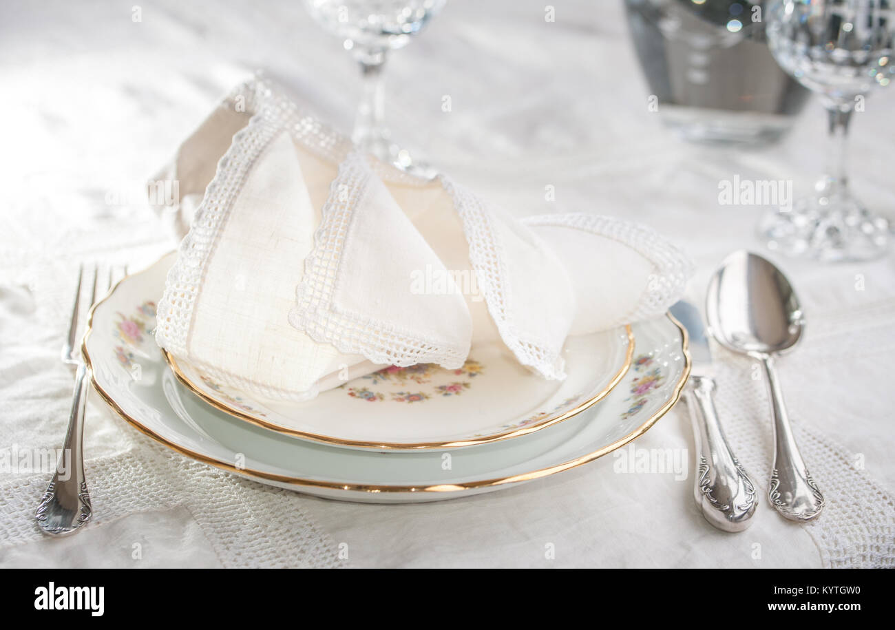 Luxury dinner set arranged on a table with vintage cream lace ...