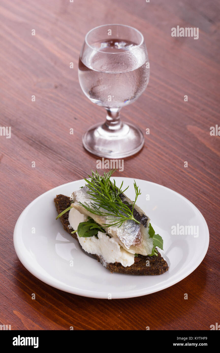 Shot of vodka with herring and cheese on a slice of dark bread Stock ...