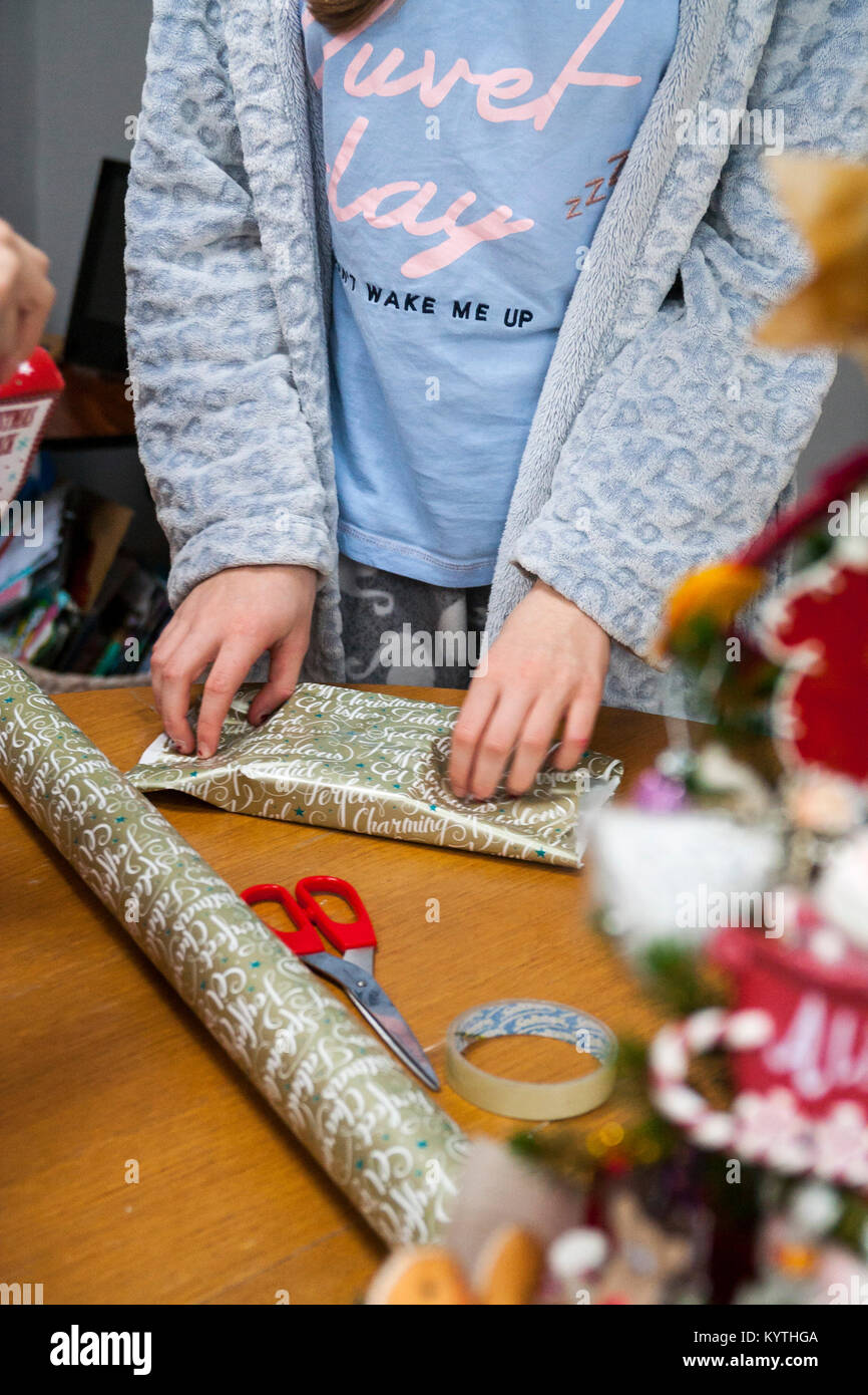 Child wrapping Christmas gifts / presents with scissors and cellotape ...