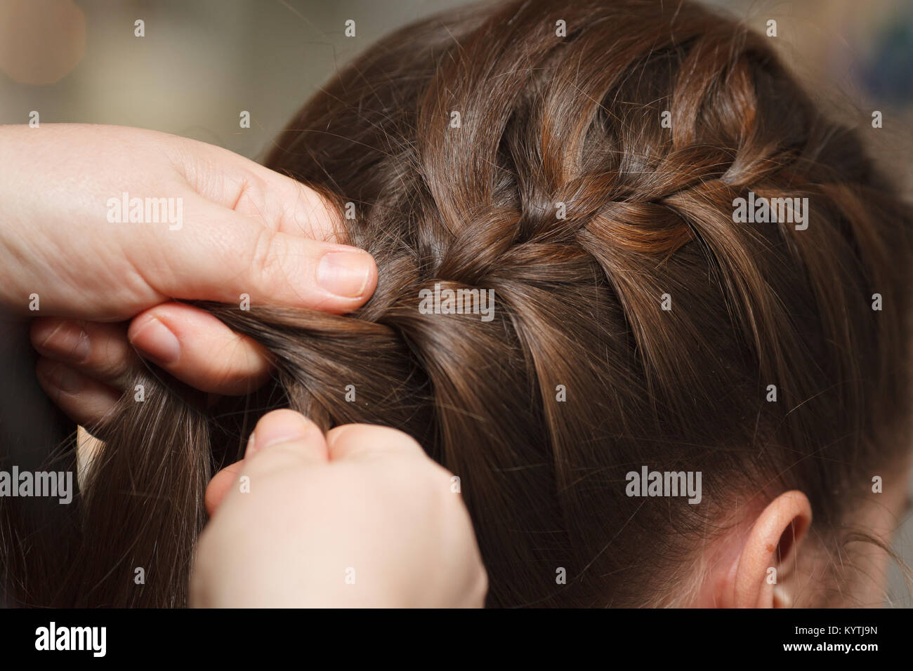 Female hands braid dark hair, close-up Stock Photo - Alamy