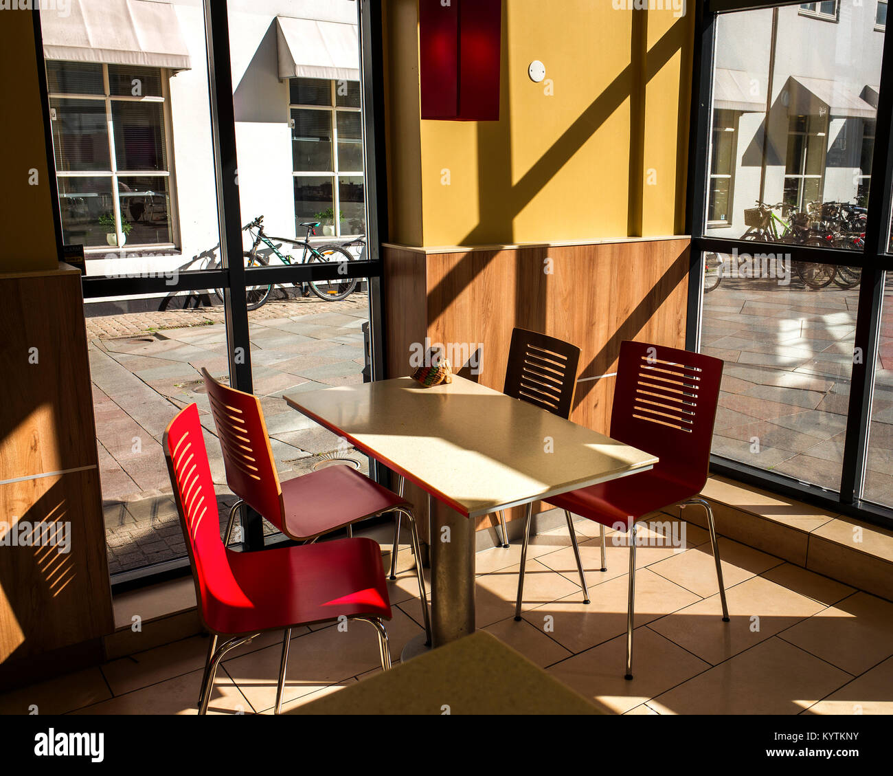 Modern chairs and table sun throwing shadows accross fast food hi-res ...