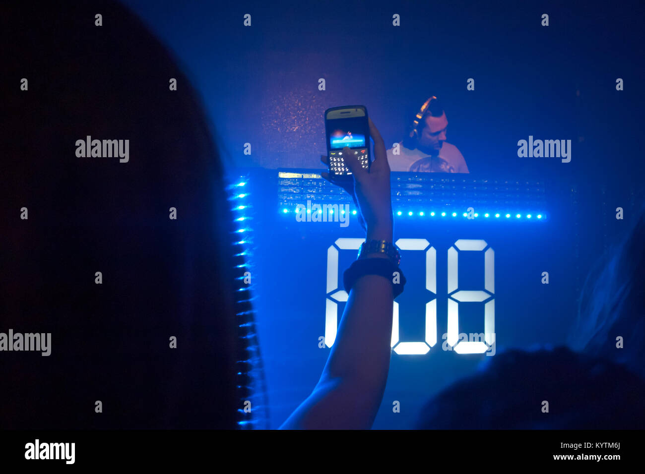 Techno DJ on the stage, trance DJ party, city nightlife in the club ...