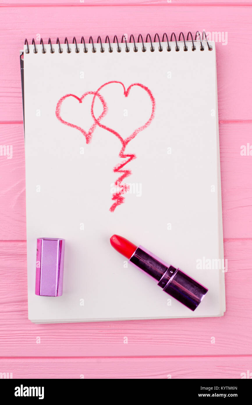 Draw of hearts on paper notebook. Two hearts drawn with red lipstick on ...