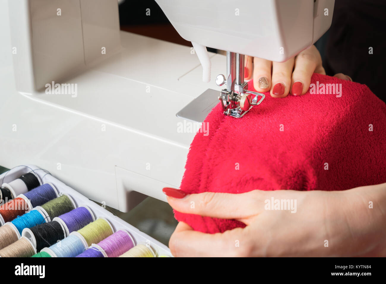 Young woman sewing fabric on sewing machine,sewing process in the phase ...