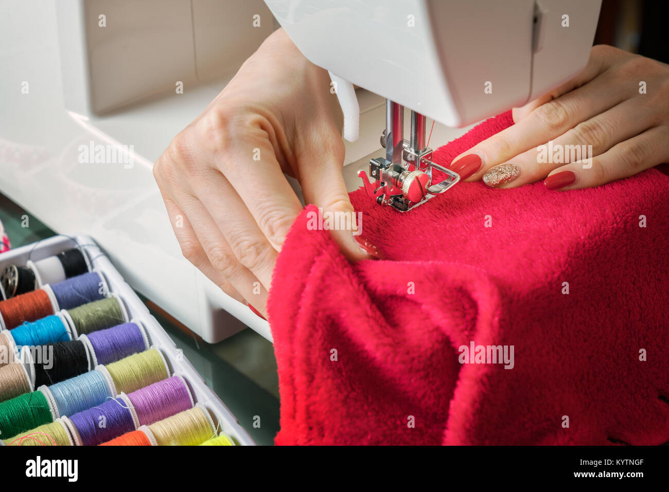 Young woman sewing fabric on sewing machine,sewing process in the phase ...