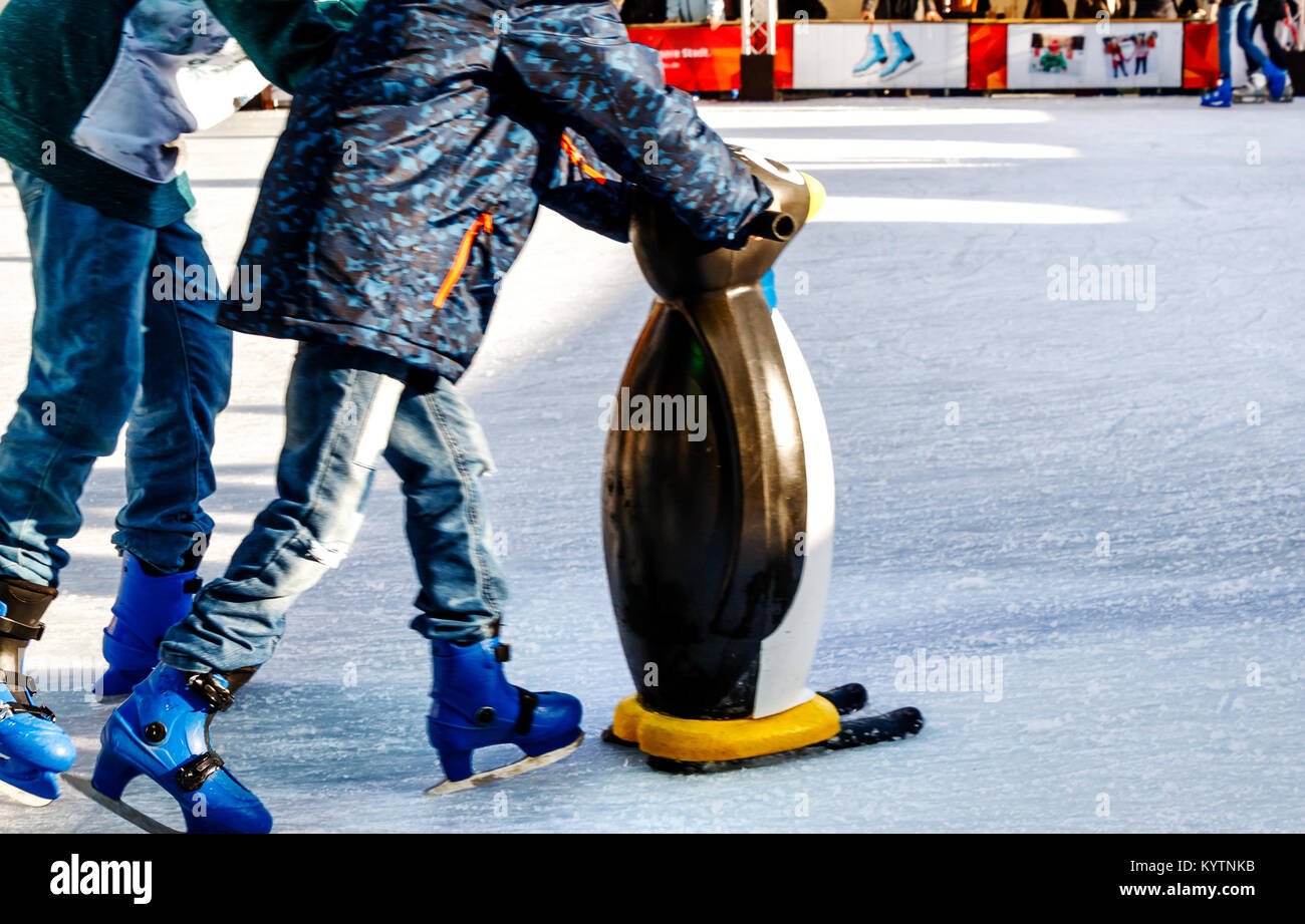 Learning ice skating with plastic penguin helps Stock Photo - Alamy