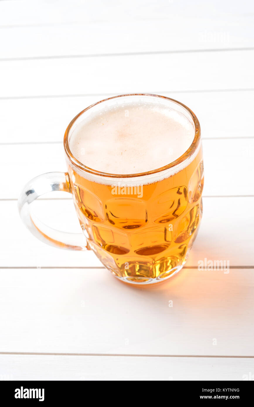Beer glass on white wooden table. Close up Stock Photo - Alamy