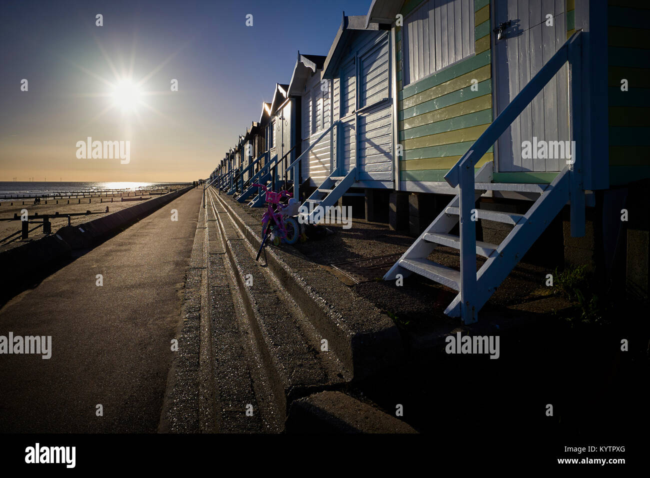 A line of beach huts into winter sun at Frinton on Sea, Essex Stock ...