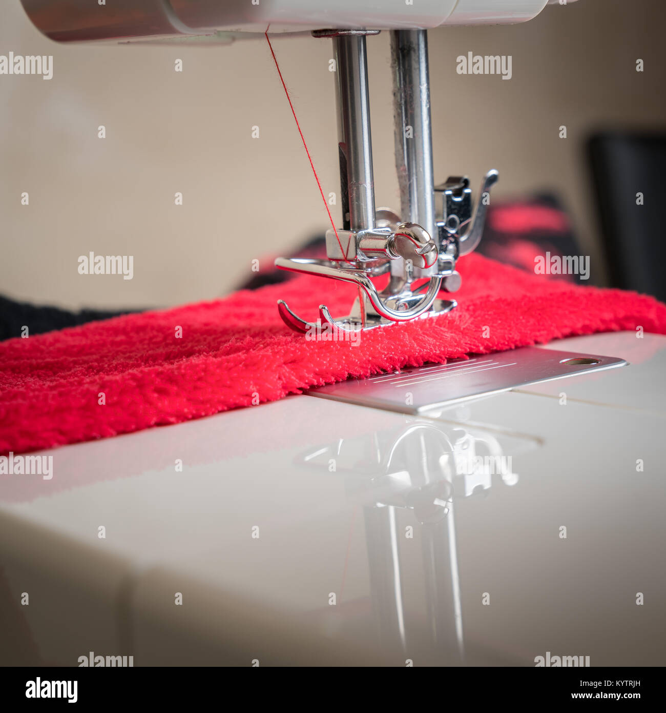 sewing machine close up and red cloth, sewing process in the phase of ...