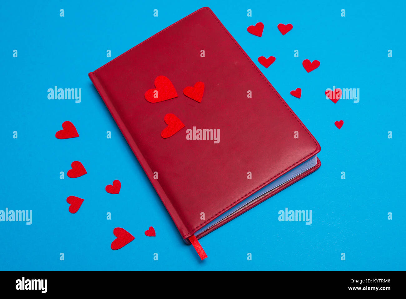 Diary lying on a blue background with hearts Stock Photo - Alamy