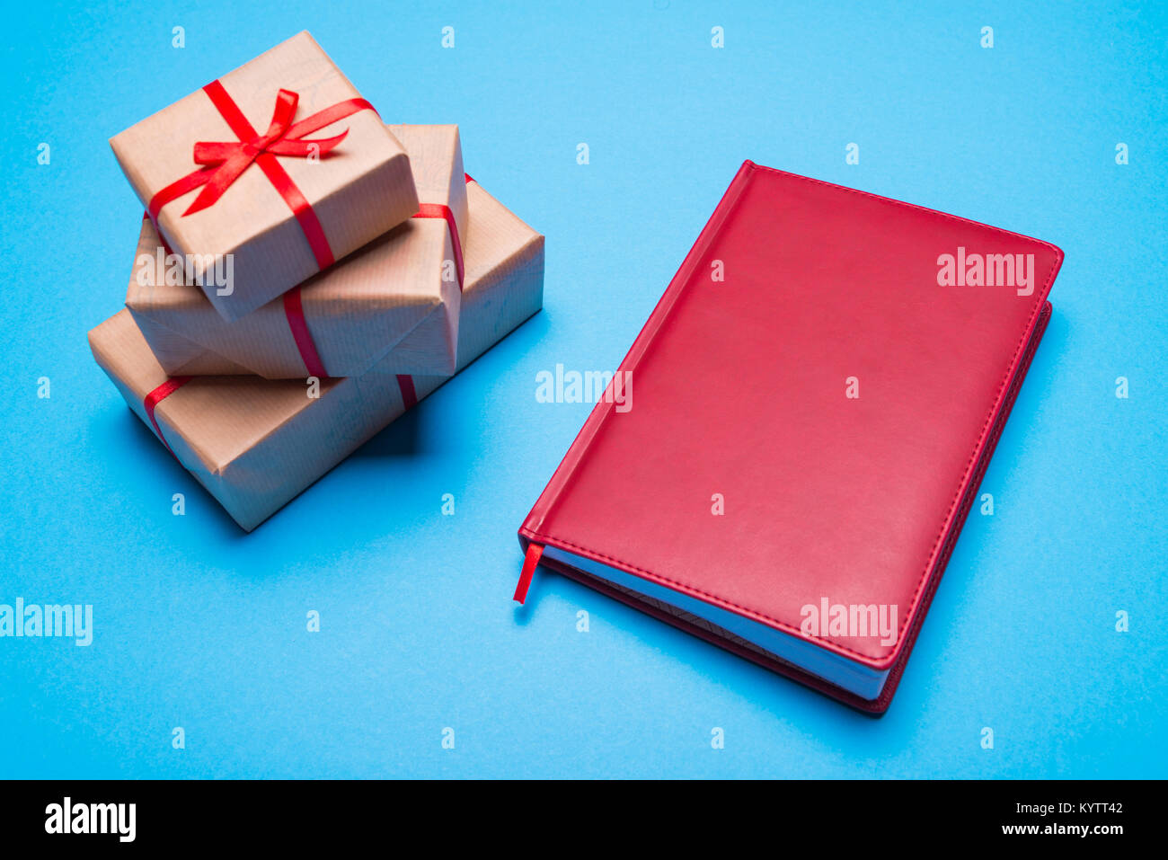 Gift boxes with a red ribbon, lying on the background with a diary ...
