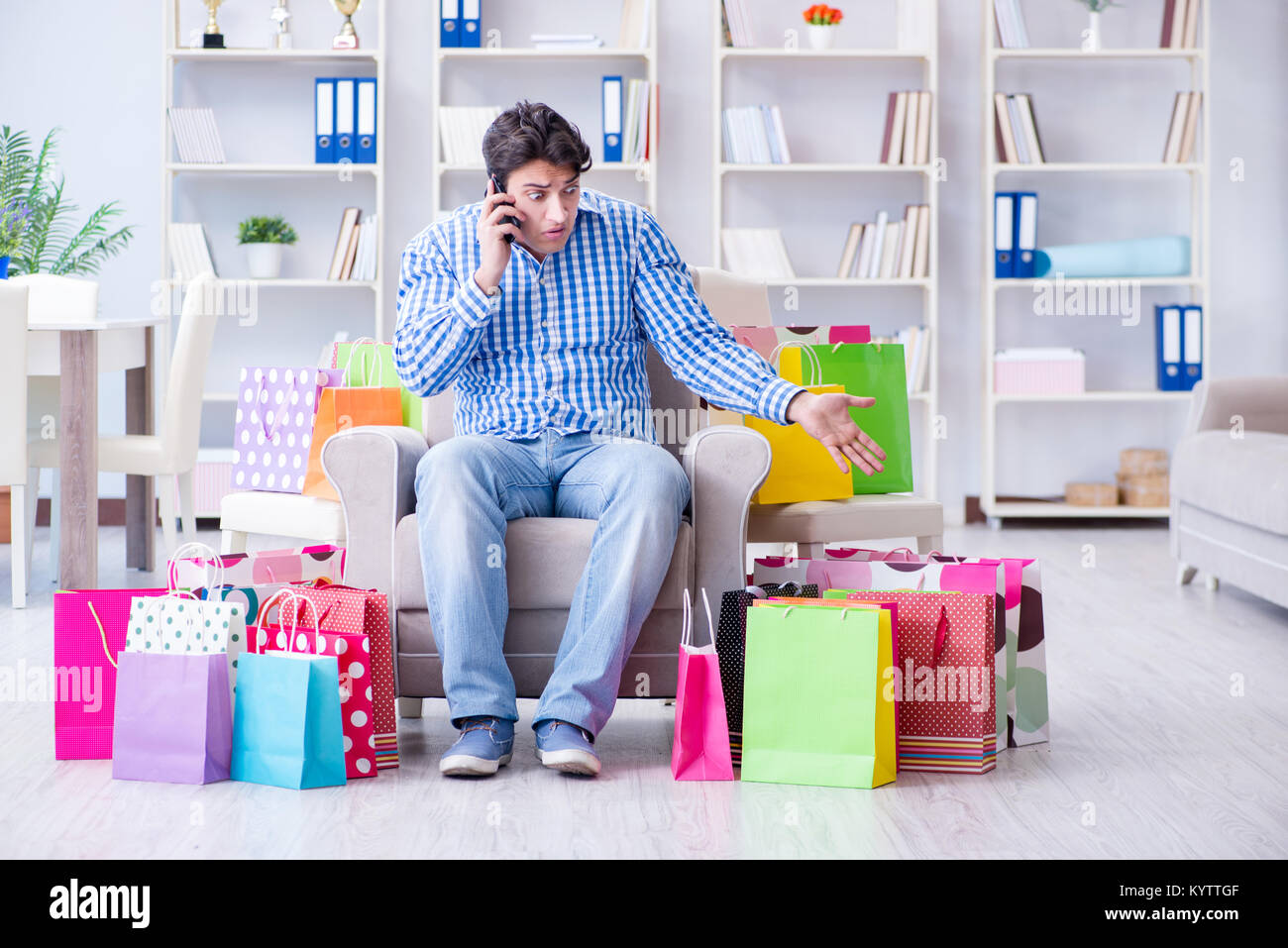 Young man after excessive shopping at home Stock Photo - Alamy