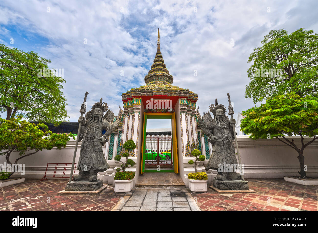 Stone warrior statues stand guard at a gated entrance to the Wat Pho ...