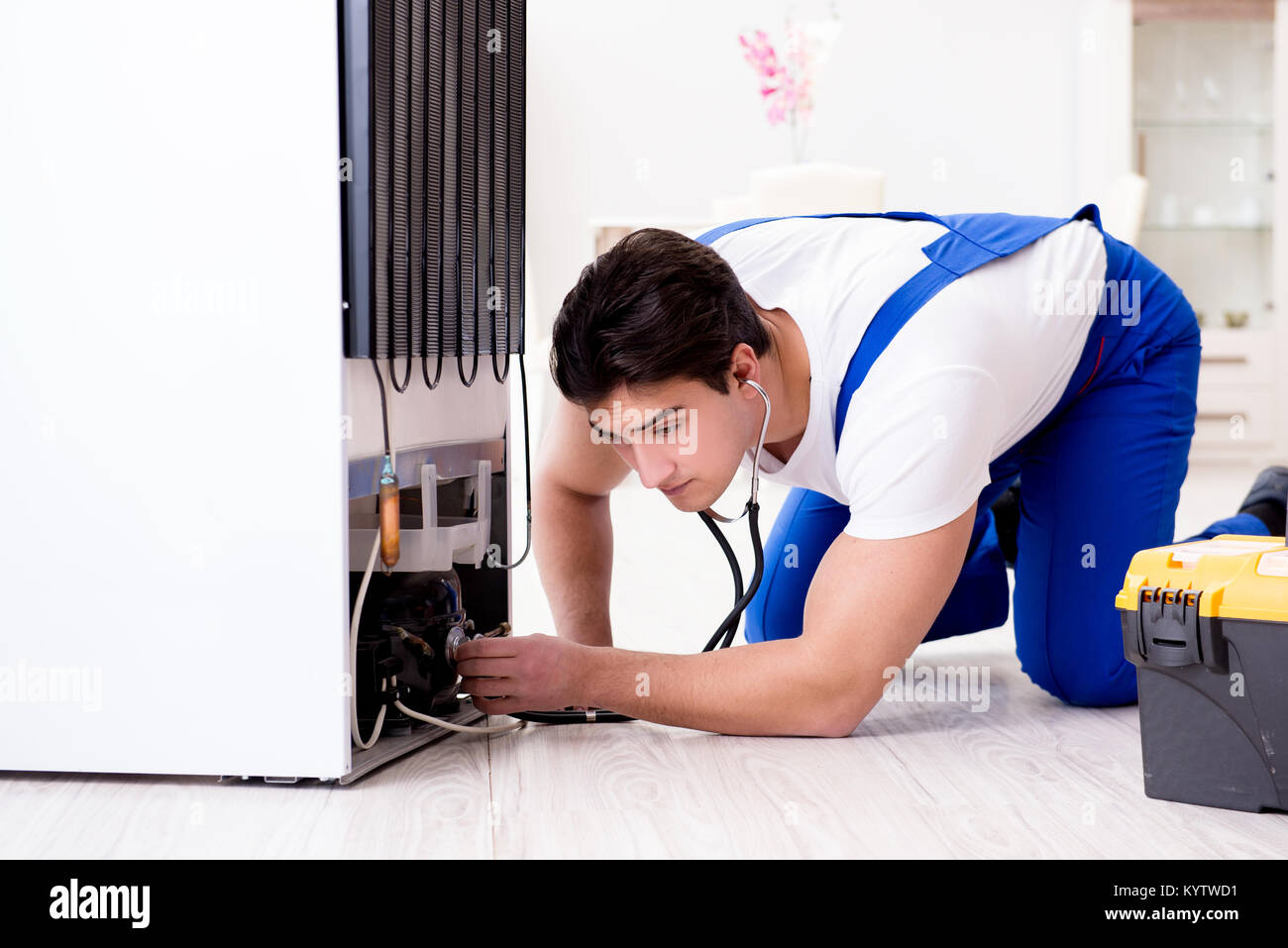 Repairman contractor repairing fridge in DIY concept Stock Photo - Alamy