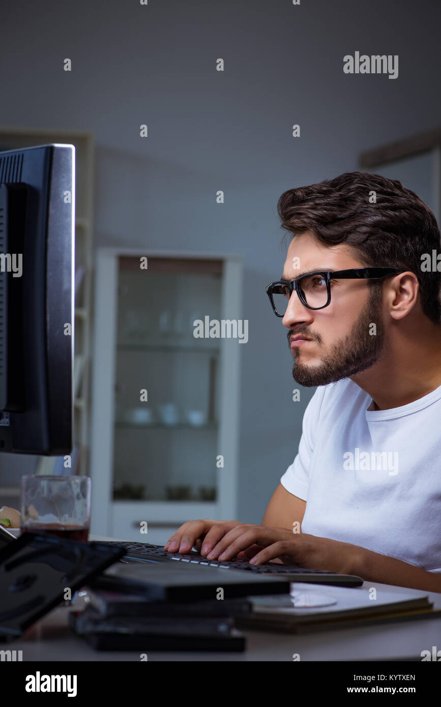 Young man staying late in office to do overtime work Stock Photo - Alamy