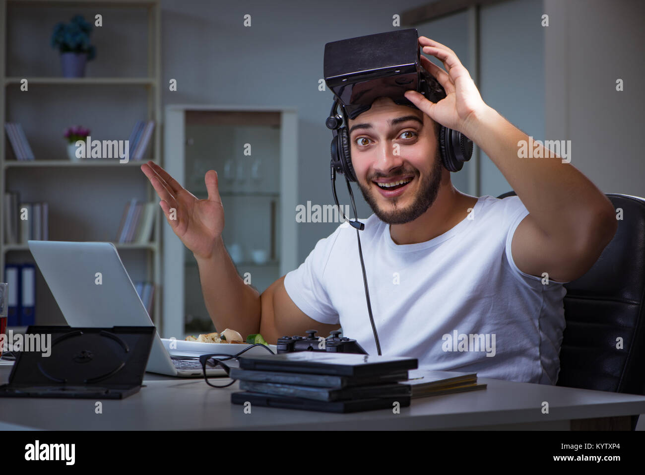 Young man playing games long hours late in the office Stock Photo - Alamy