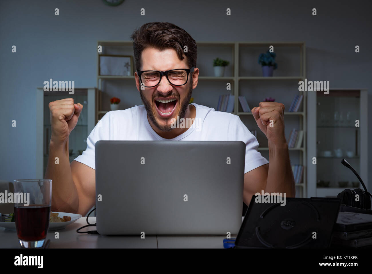 Young man staying late in office to do overtime work Stock Photo - Alamy