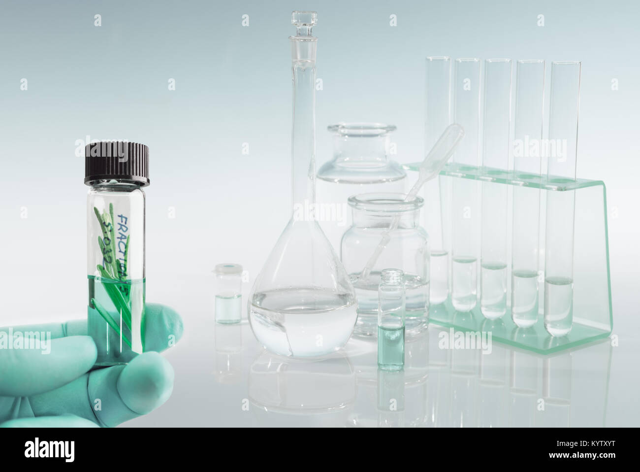 Scientific background with chemical flasks, tubes and hand holding a ...