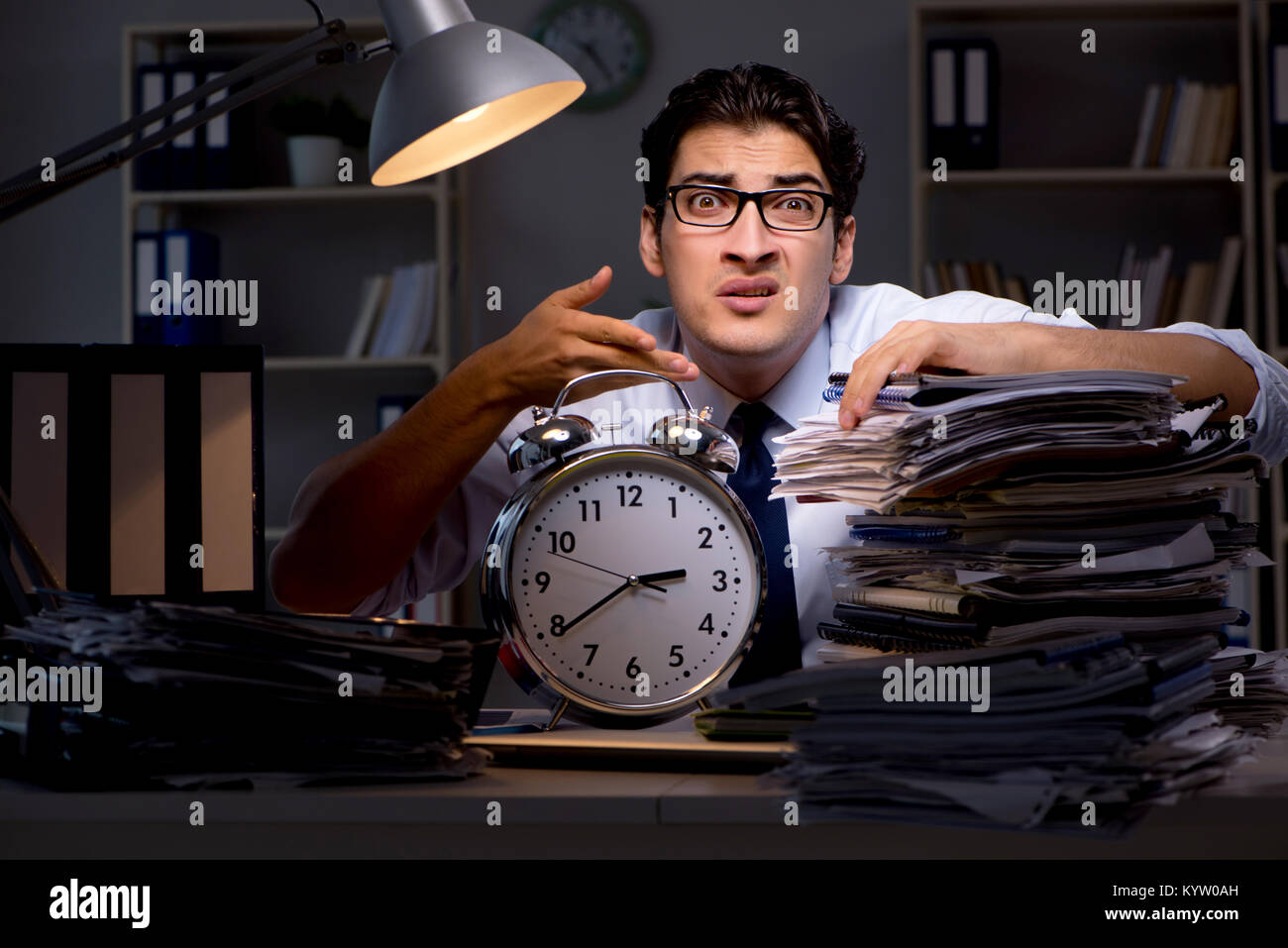 Young businessman working overtime late in office Stock Photo - Alamy
