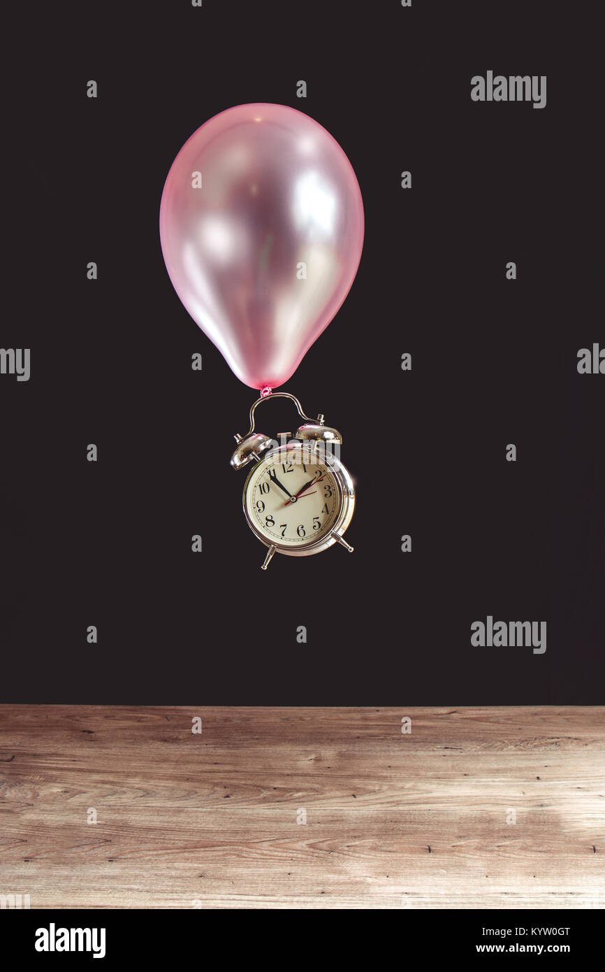 Time flies concept - picture of an old metal clock attached to a pink ...