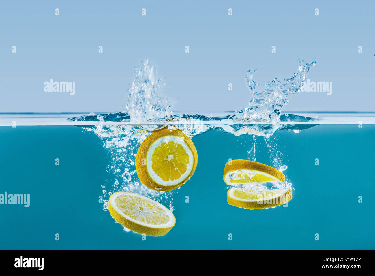 side view of fresh lemon slices falling into water with splashes Stock ...