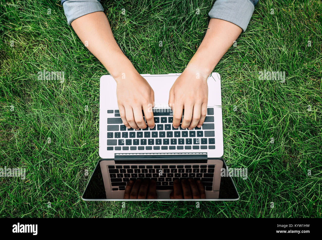 Cropped shot of person typing on laptop with blank screen outdoors ...