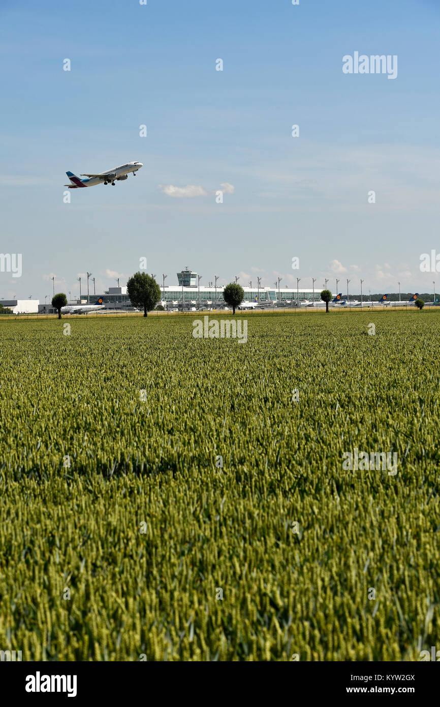 Field, airport area, satellite building, with Eurowings airplane taking ...