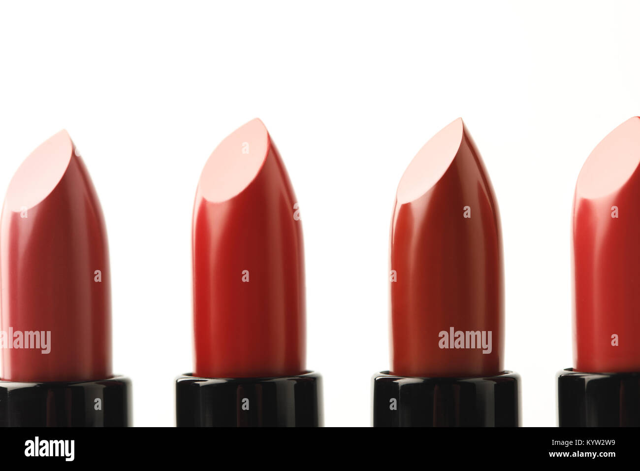 close-up shot of row of lipsticks of various shades isolated on white ...