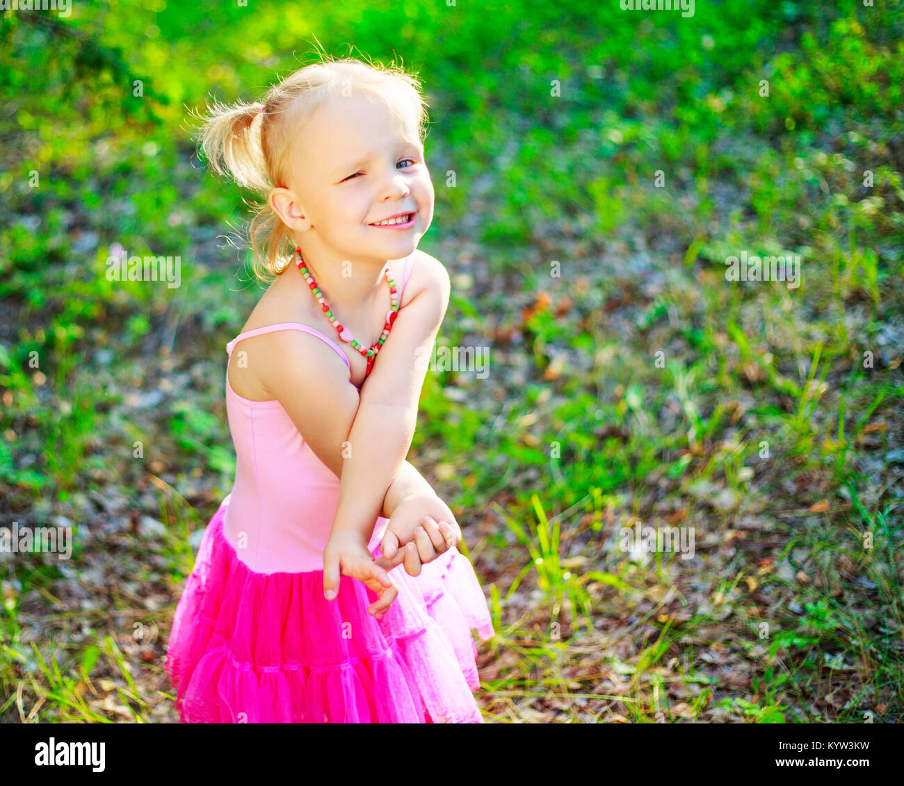 shy little girl wearing a pink dress, in the summer park Stock Photo ...