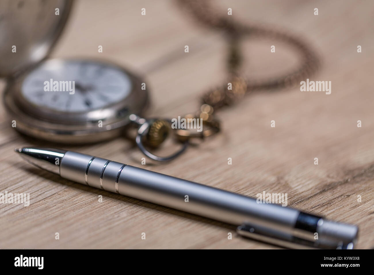Pen and Antique Silver Pocket Watch on Wood Stock Photo - Alamy