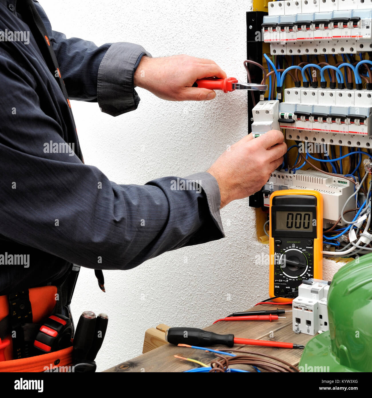 Elegant electrician technician introduces the cable into the terminal ...