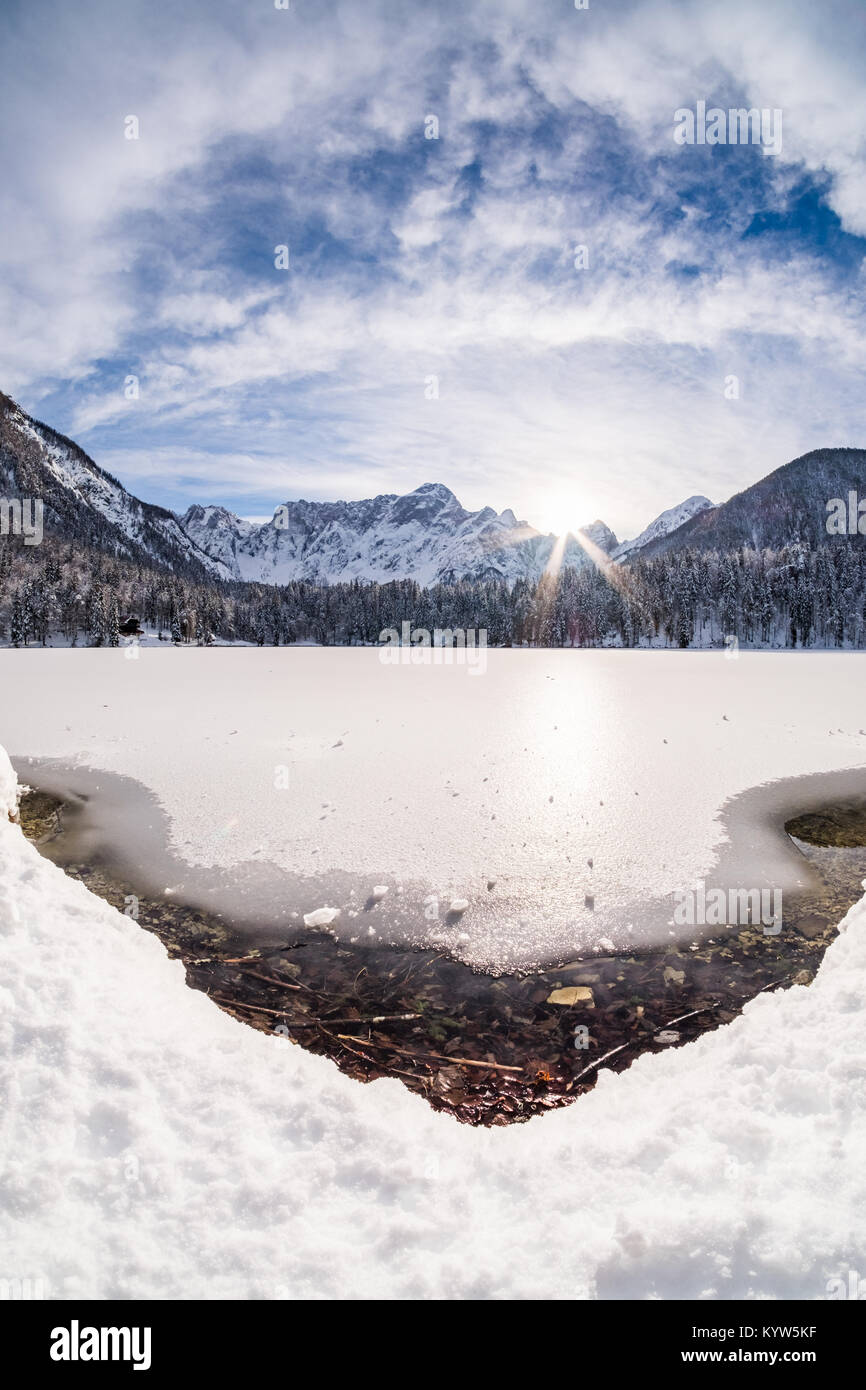 Mountain range Mangart seen from snow covert frozen lake Fusine with ...